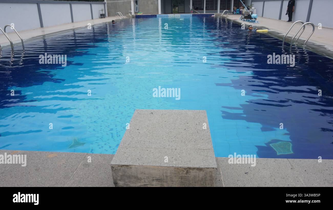 A large, clean swimming pool with crystal-clear water, equipped with ...