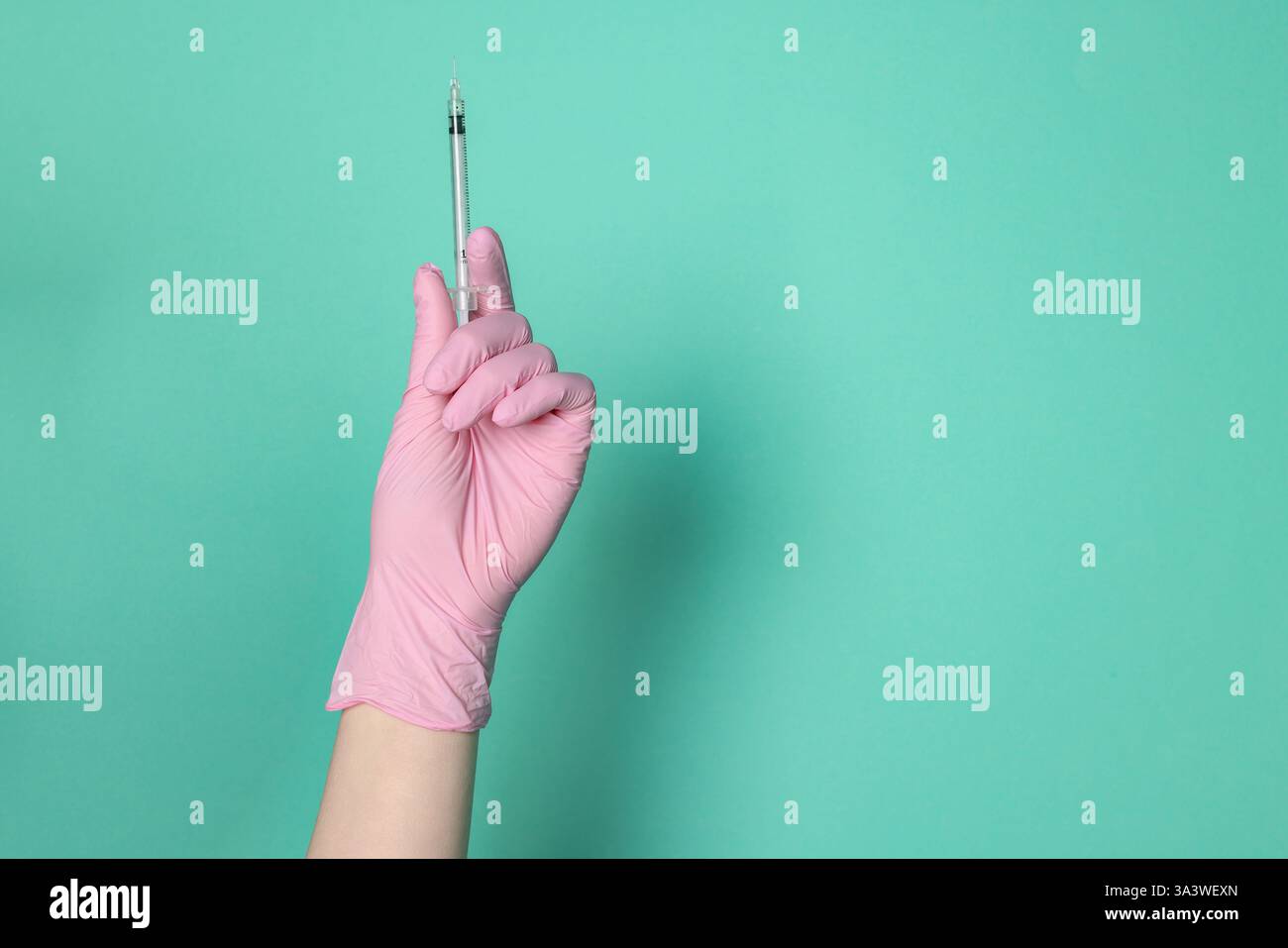 Doctor holding syringe with medication on turquoise background, closeup ...