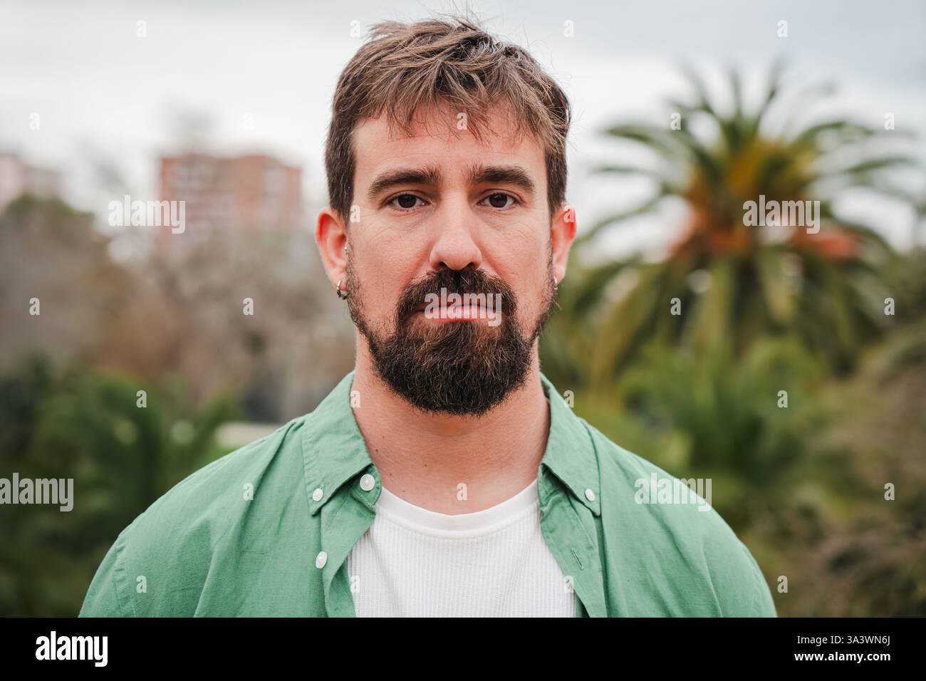 Portrait of a young man with a beard looking directly at the camera ...