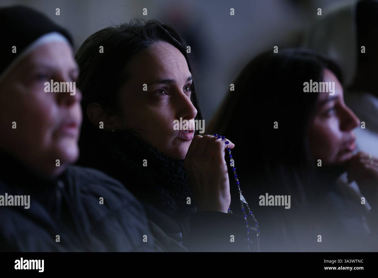 Vatican, Italy. 17th Mar, 2025. A woman recites the rosary during the ...