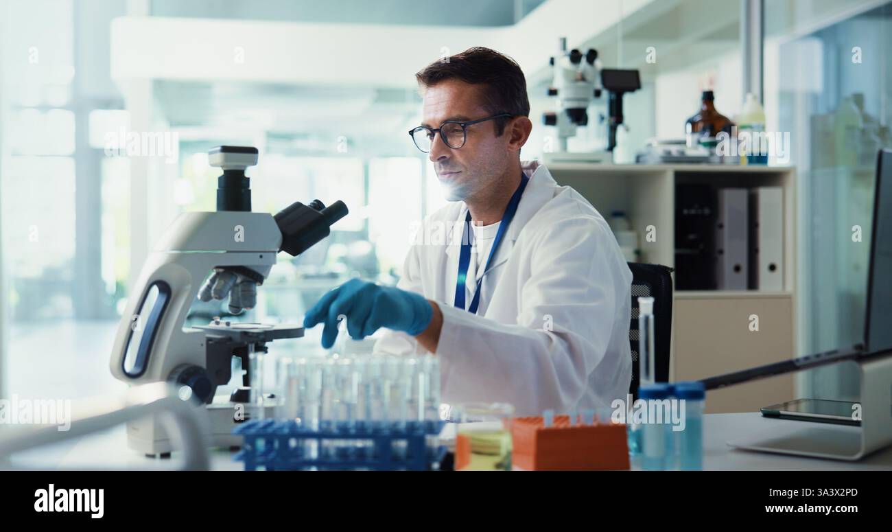 Scientist, man and sample by microscope in lab for medical research ...