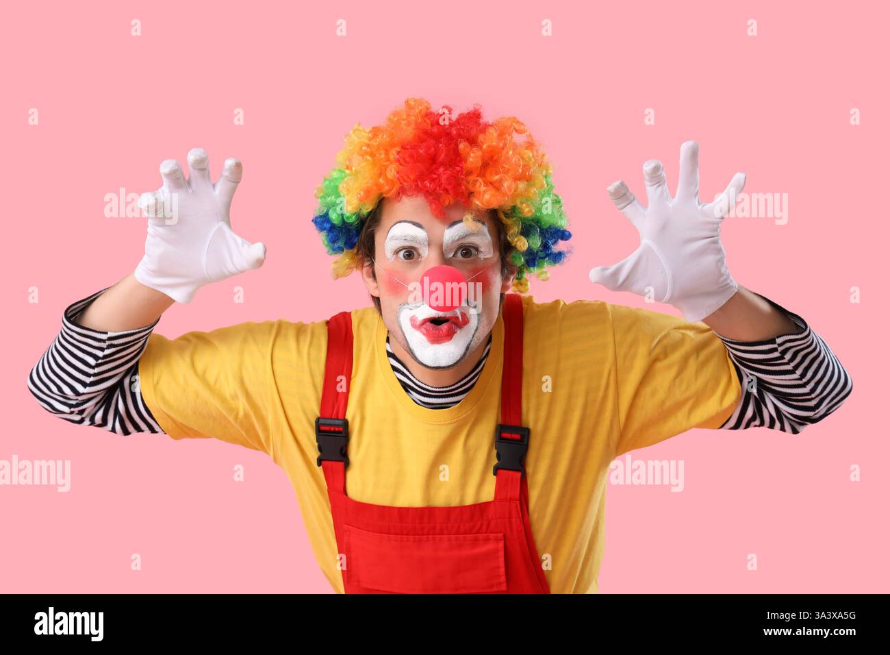 Portrait of playful clown on pink background. April Fool's day ...