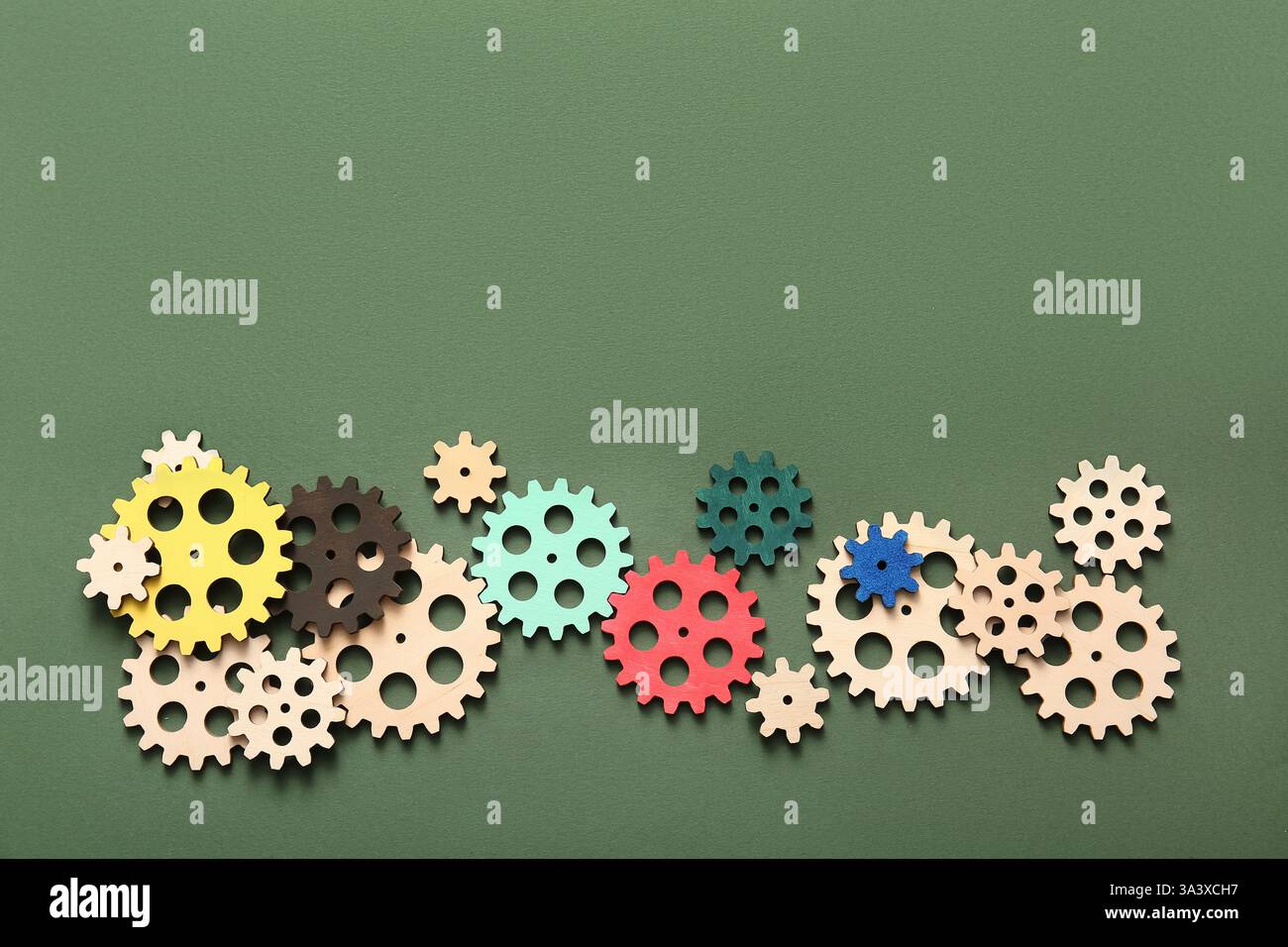Wooden gears on green background Stock Photo - Alamy