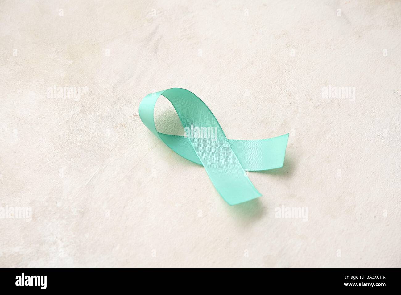 Turquoise ribbon on light grunge background. Cervical Health Awareness ...