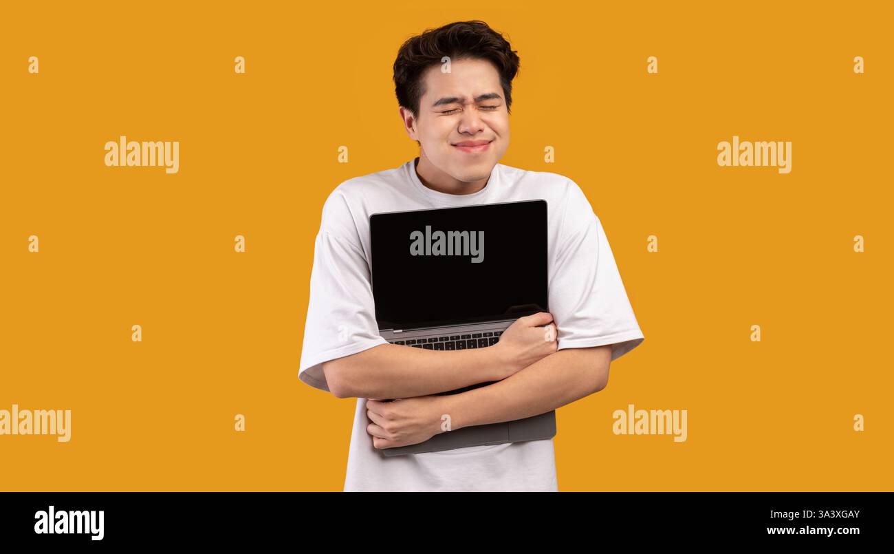 Technology Lover. Excite asian guy hugging personal computer Stock ...