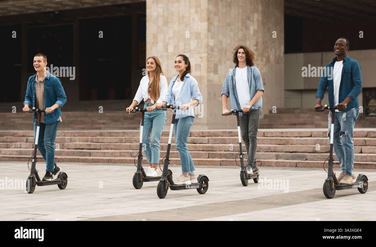 Five friends having pleasant ride on motorized kick scooters Stock ...