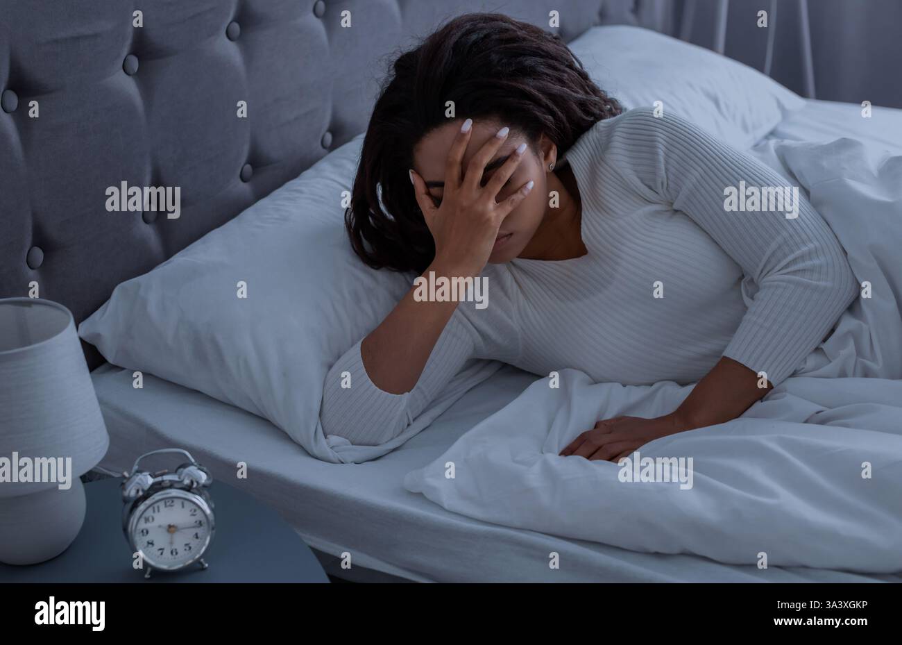 Black woman suffering from insomnia covering face Stock Photo - Alamy