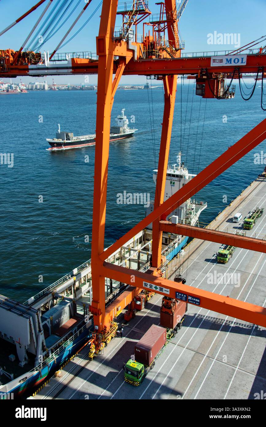 Cargo is loaded onto cargo ships at the kana container yard in Tokyo ...