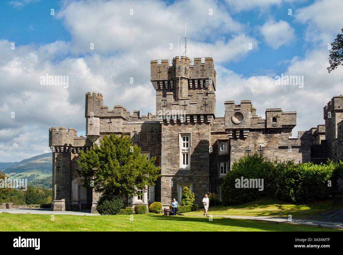 Visitors stroll trough the grounds of Wray Castle in the Lake District ...