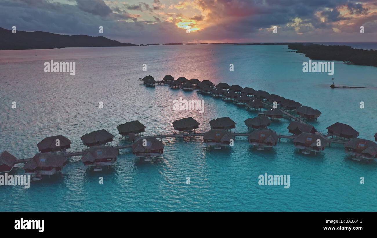 Colorful tropical sunset over overwater bungalows resort, Bora Bora ...