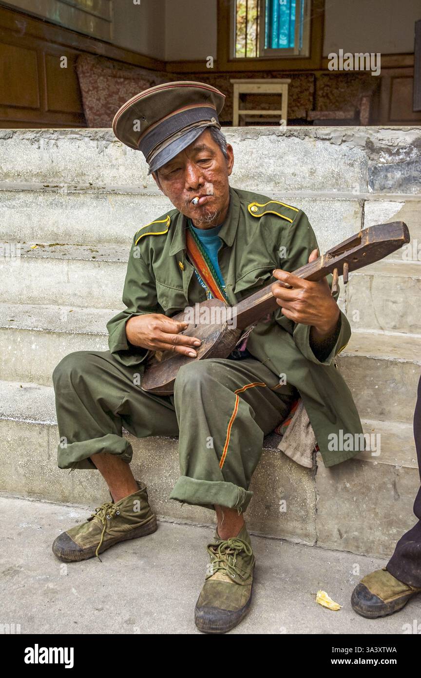 Old soldier playing a plaintive tune in Lumadeng market, Nujiang Stock ...