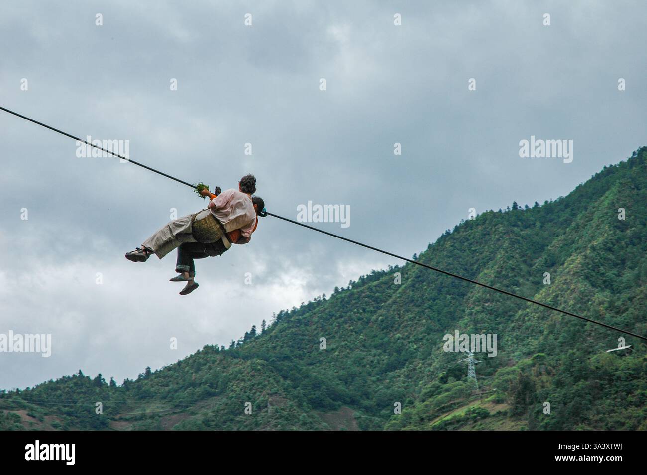 Foreigner being given a ride on a rope bridge over the Nu River Stock ...