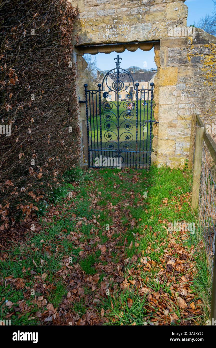 Ornate wrought iron gate attached to a limestone gateway at Nunnington ...