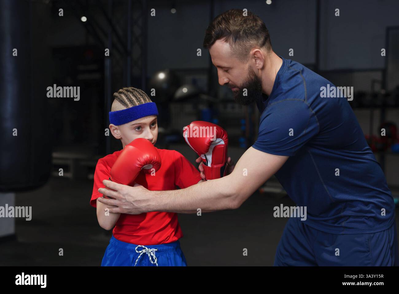 Boxing coach training boy in sport center Stock Photo - Alamy