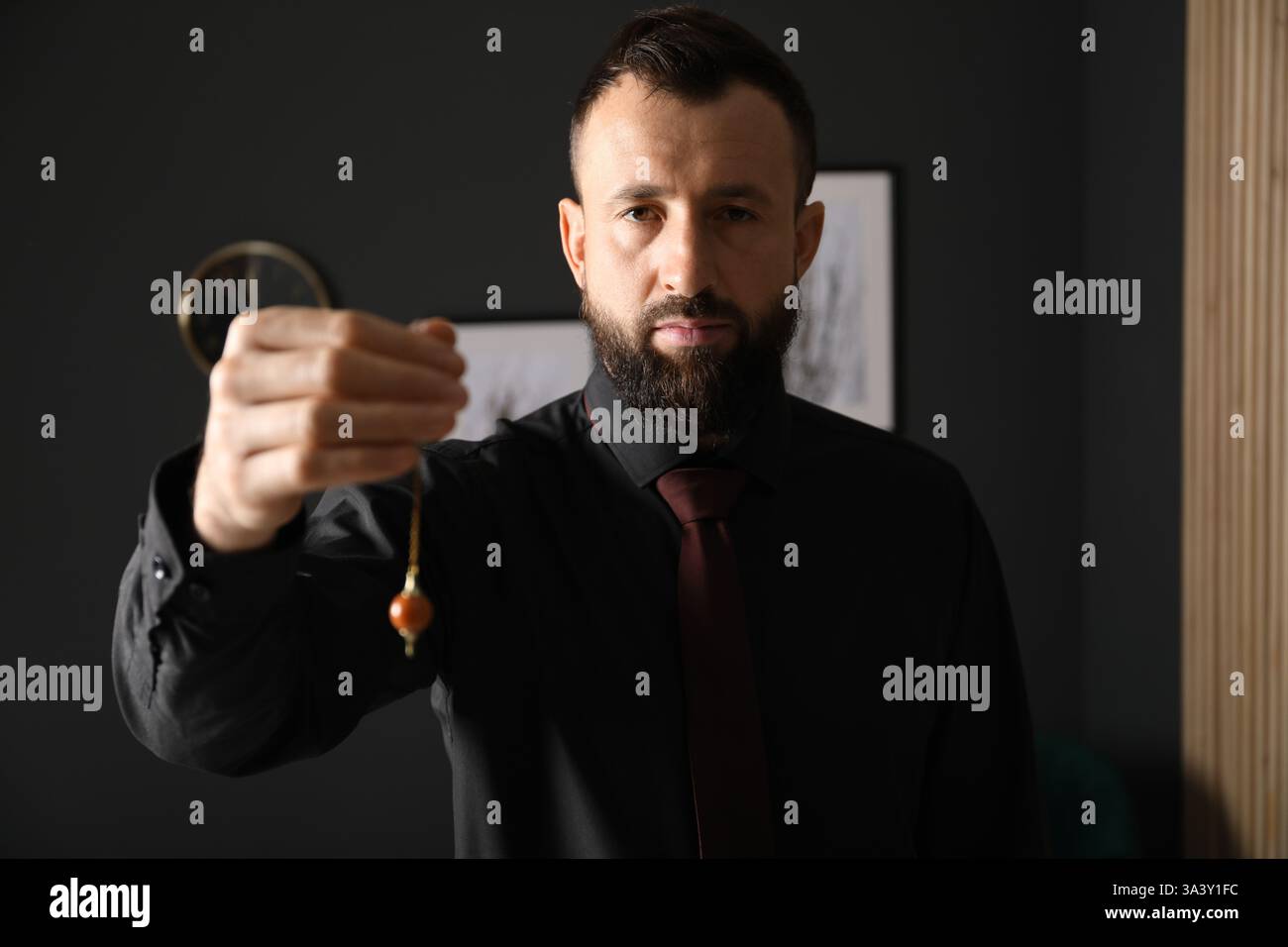Hypnosis session. Man with pendulum in office Stock Photo - Alamy