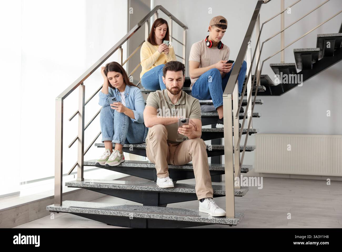 Internet addiction. Group of people with smartphones on stairs indoors ...