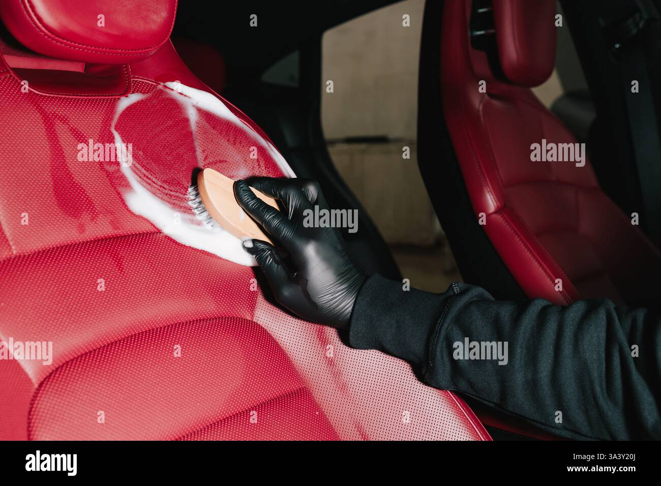 Car detailing process of cleaning leather auto seat with soap foam at ...