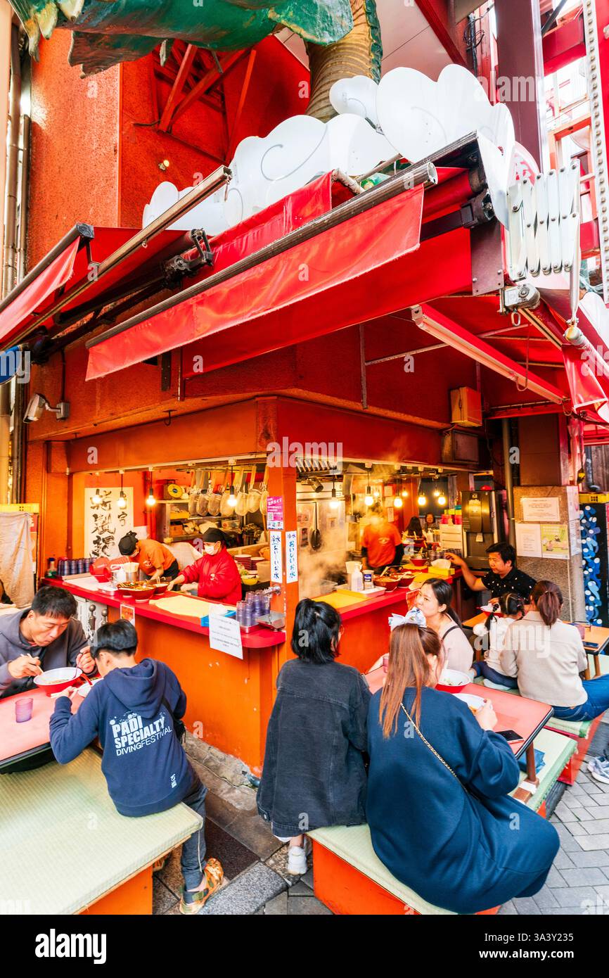 Japanese and Chinese tourists sitting at tables outside the very ...
