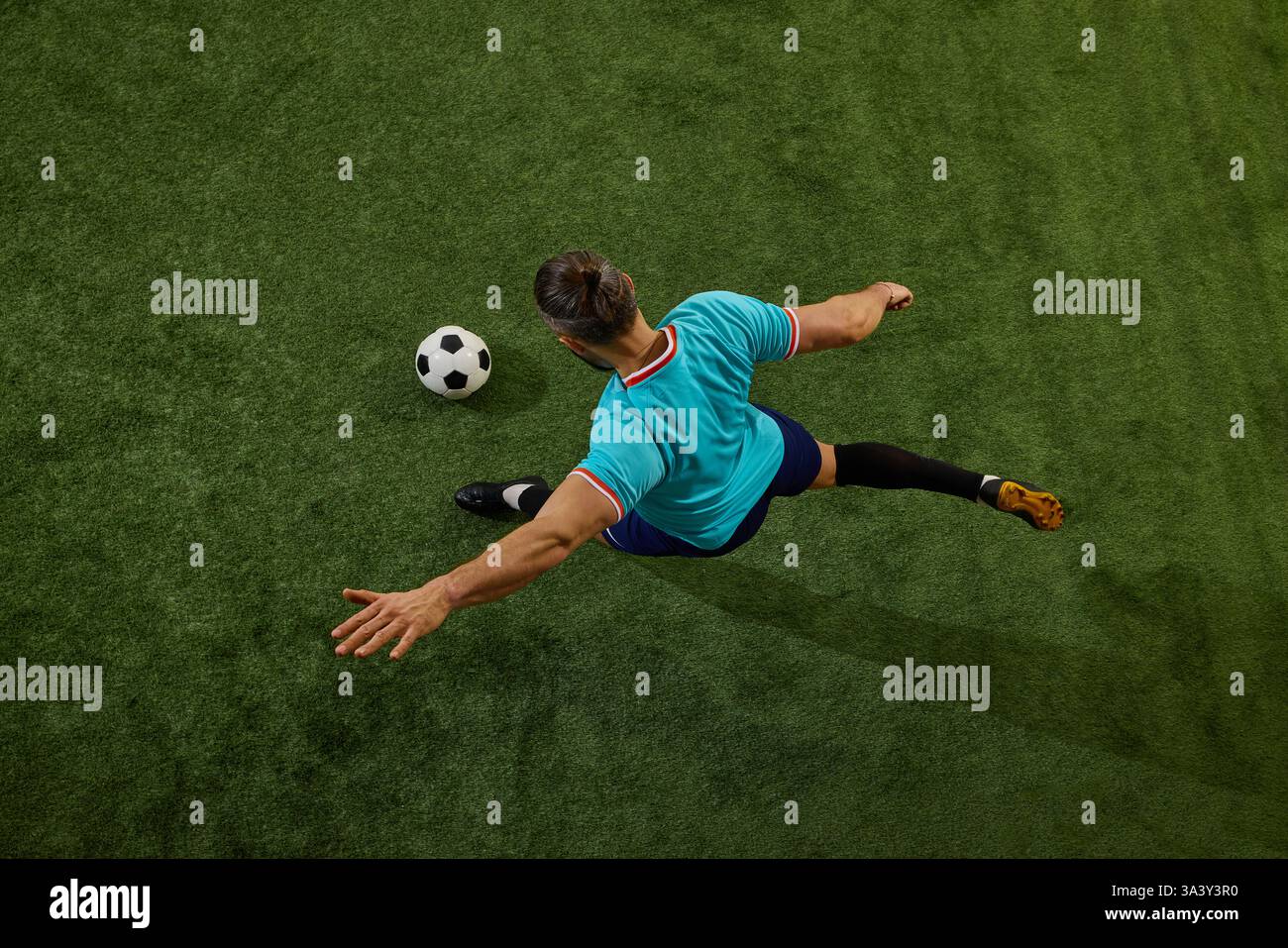Top-down perspective of skilled football player executing powerful pass ...
