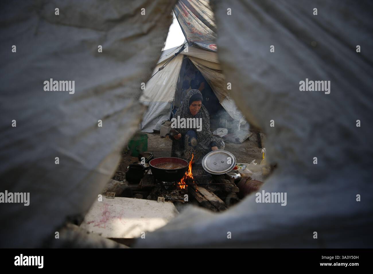 Gaza. 17th Mar, 2025. A Palestinian is pictured in a tent in Jabalia ...