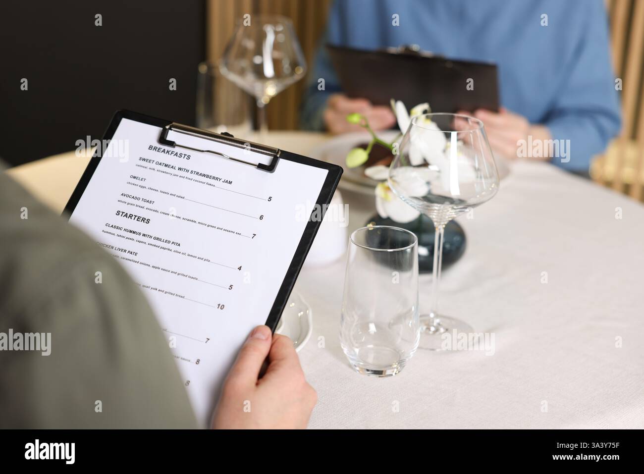 Couple choosing dishes from menu at table in restaurant, closeup Stock ...
