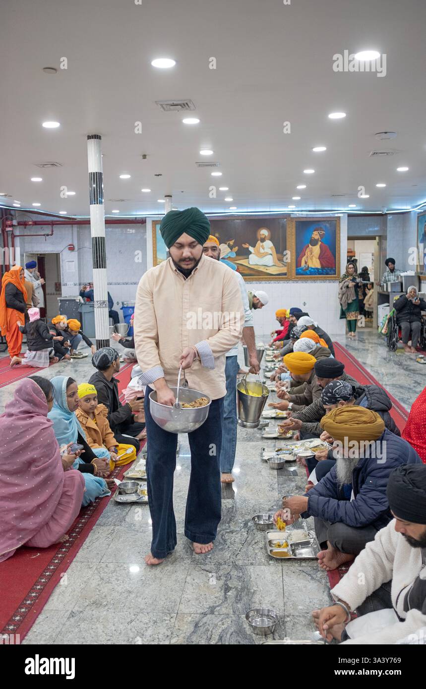Volunteers at a Langar communal kitchen serve free vegetarian food to ...