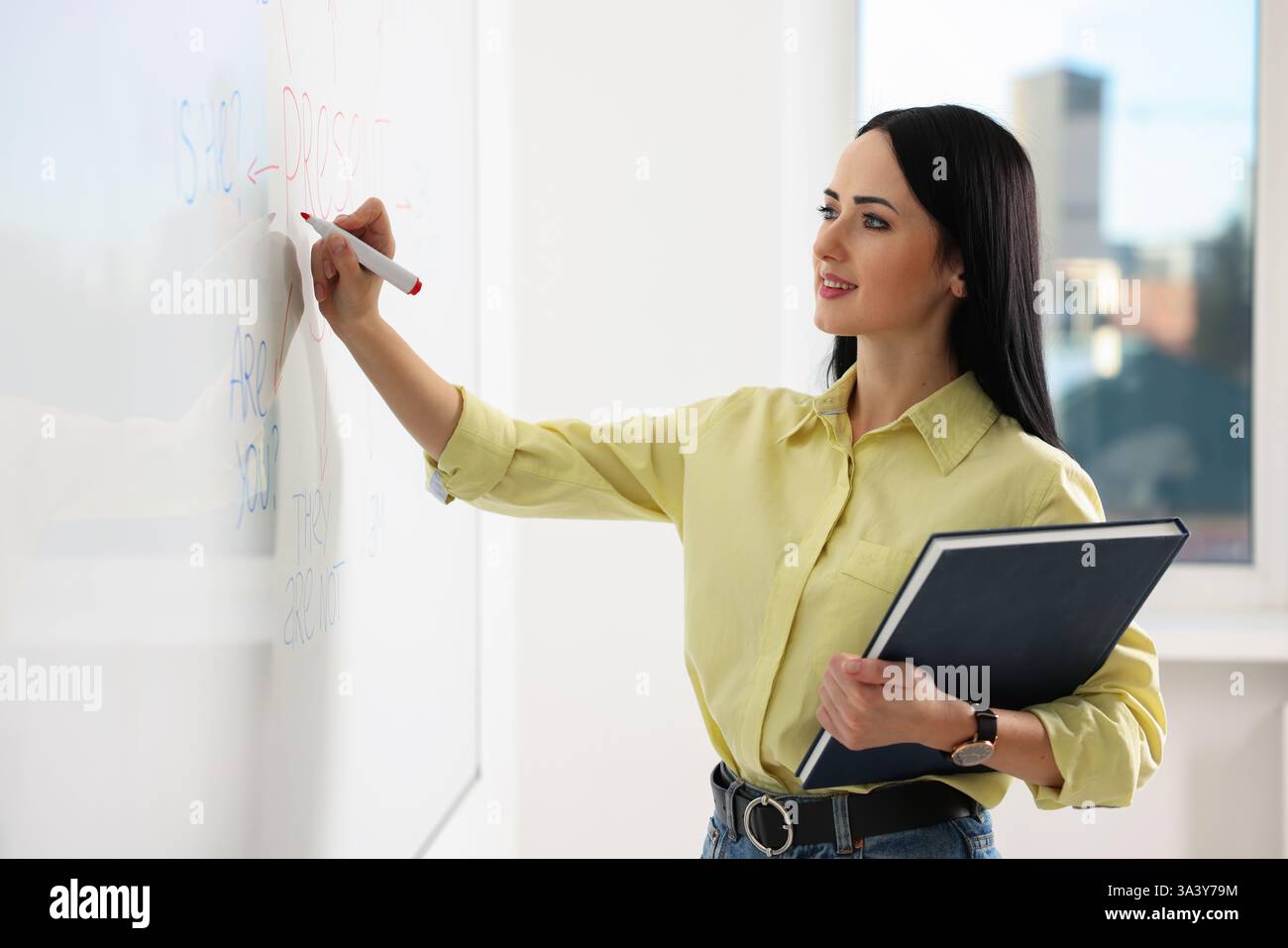 English teacher writing on whiteboard in classroom Stock Photo - Alamy