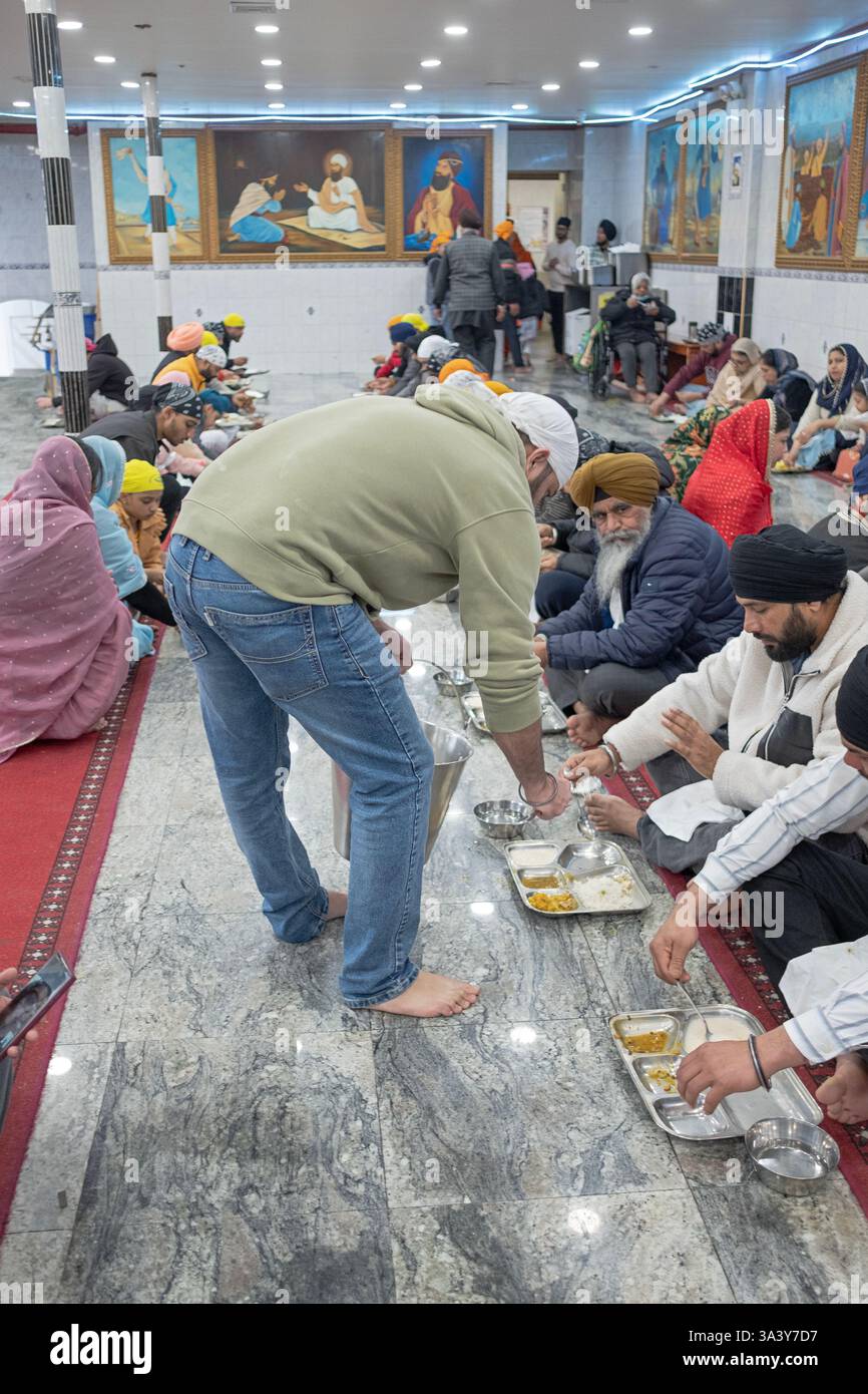 Volunteers at a Langar communal kitchen serve free vegetarian food to ...