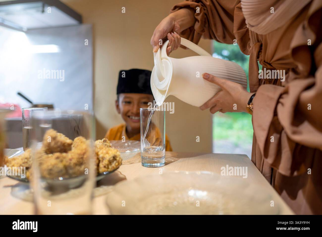 Portrait of Indonesian Muslim mother preparing food for iftar to her ...