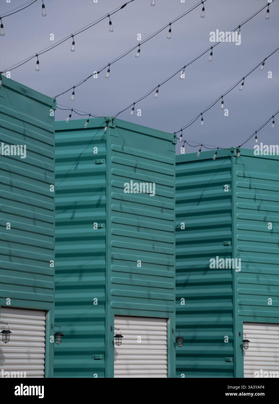 shipping containers painted turquoise standing on edge with white ...