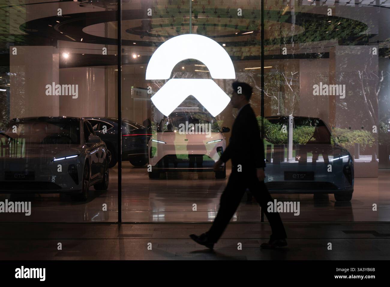 A man passes by a dealership of NIO electric cars in Shanghai, China Tuesday, March 18, 2025 ...