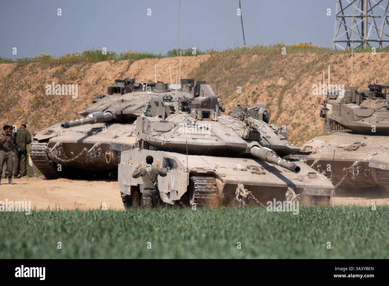 An Israeli army tank reverses near other tanks after it left the Gaza ...