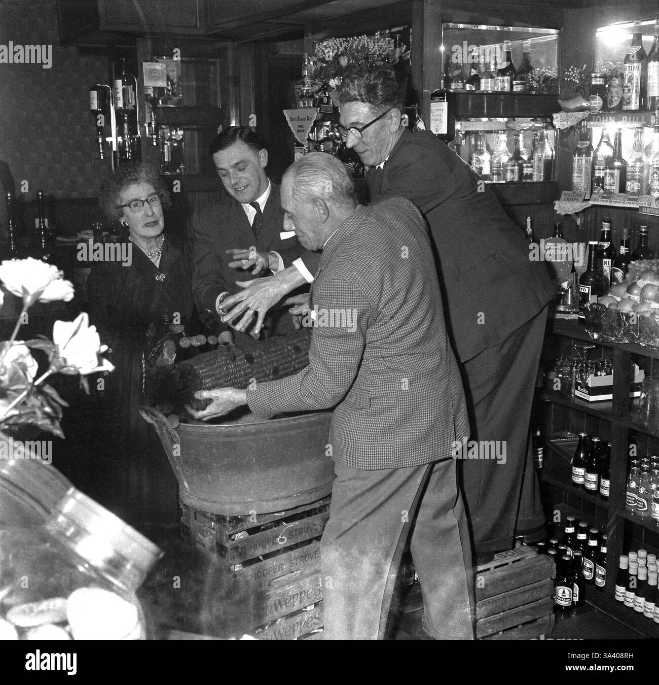 1950s, historical, behind a pub bar, three men tipping penny coins ...