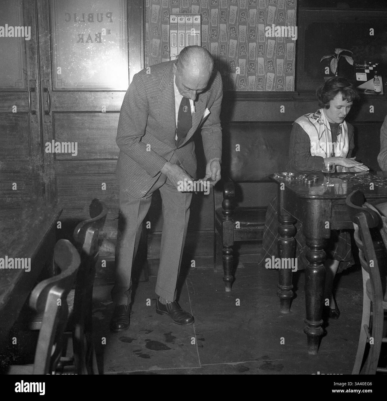 1950s, historical, counting the pennies in a East End London pub ...