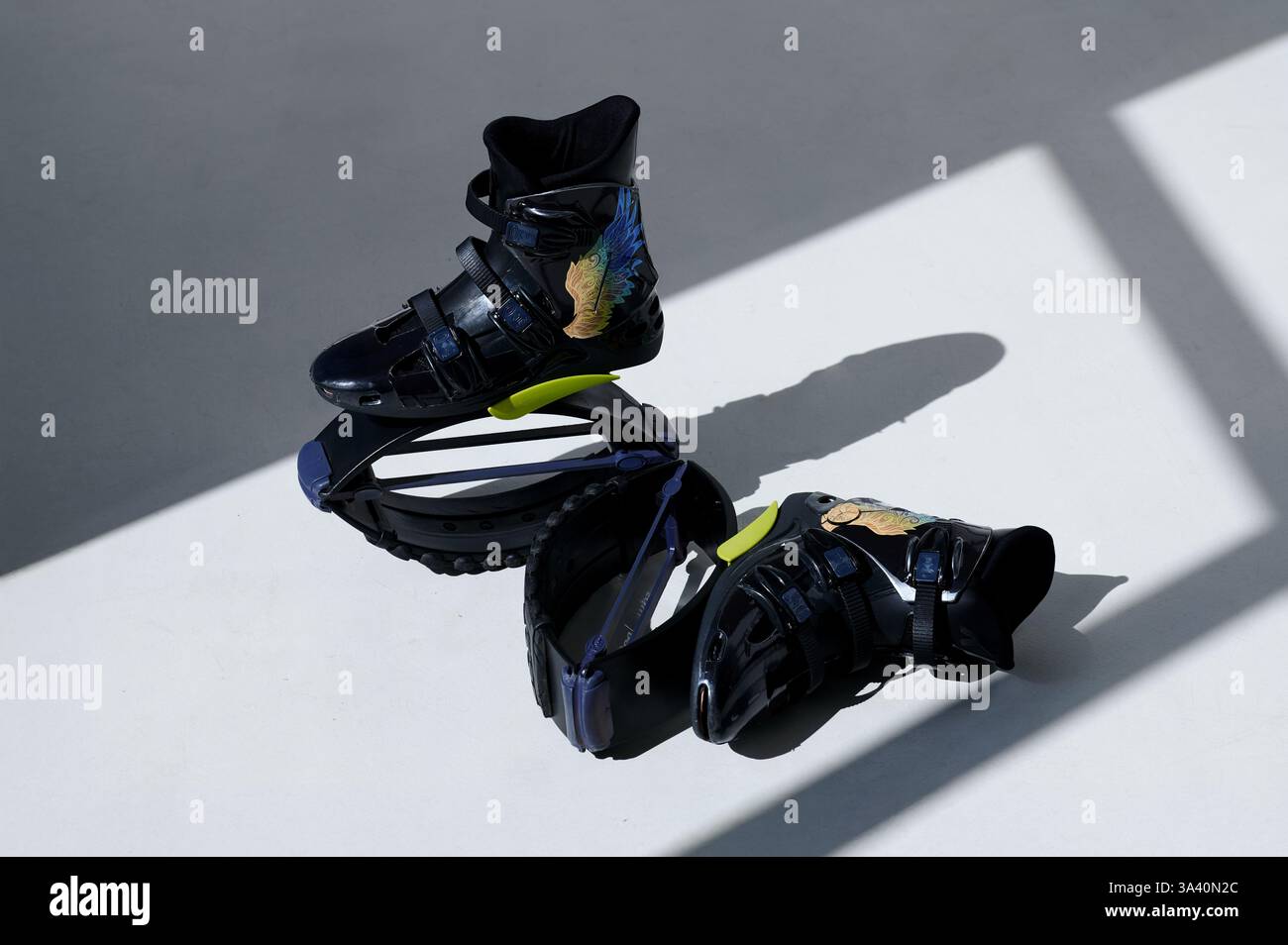A pair of black Kangoo Jumps rebound shoes on the floor, casting a ...