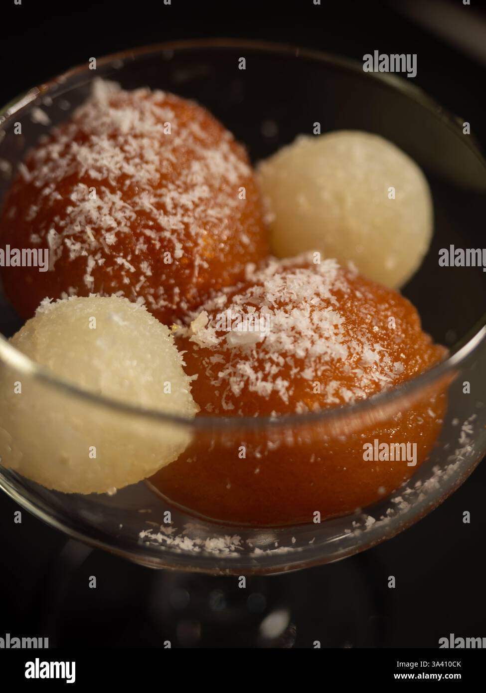 Two gulab jamun and two rasgulla, traditional indian sweets, are served ...