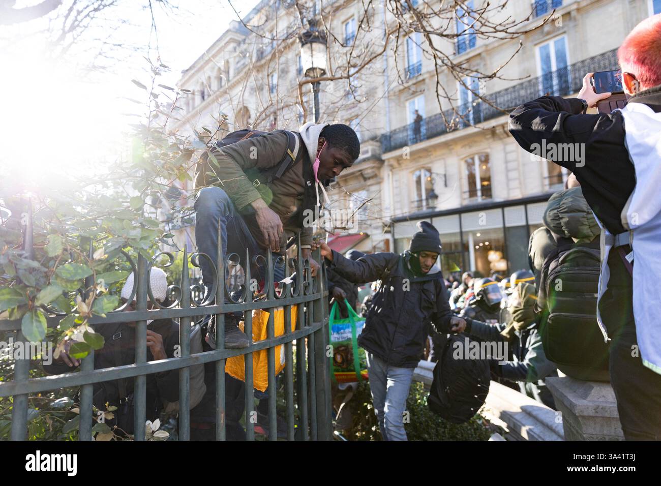 Dozens of young migrants flee from police after they used tear gas to disperse them following a ...