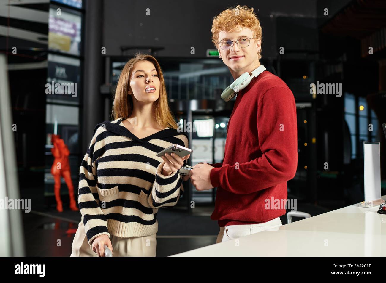 A young couple enjoys a loving interaction while checking in at an ...