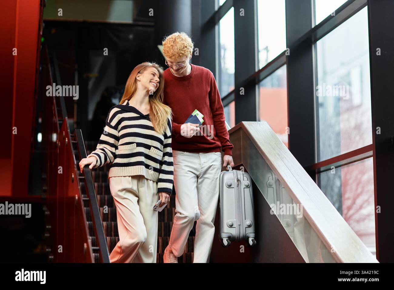 A young couple shares joyful smiles while arriving at their hotel ...