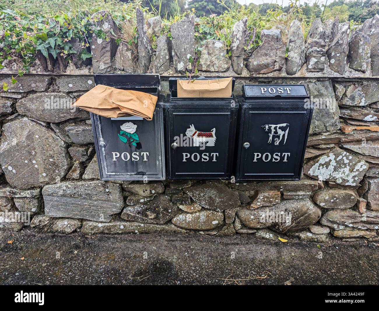 Parcels stick out from post boxes on a wall outside a number of houses ...