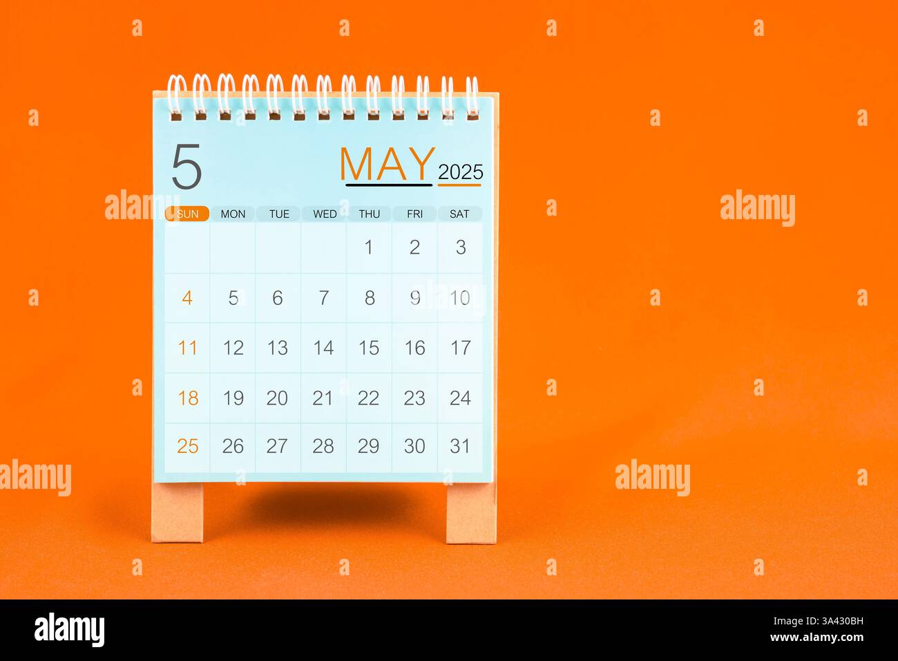May 2025 desk calendar stand on orange color textile background Stock ...