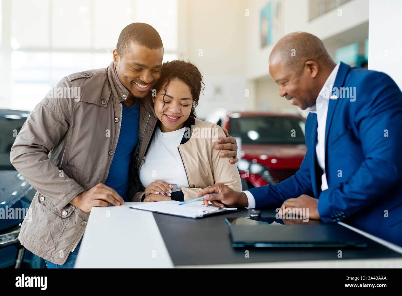 African American Couple signs purchase agreement at car dealership with ...