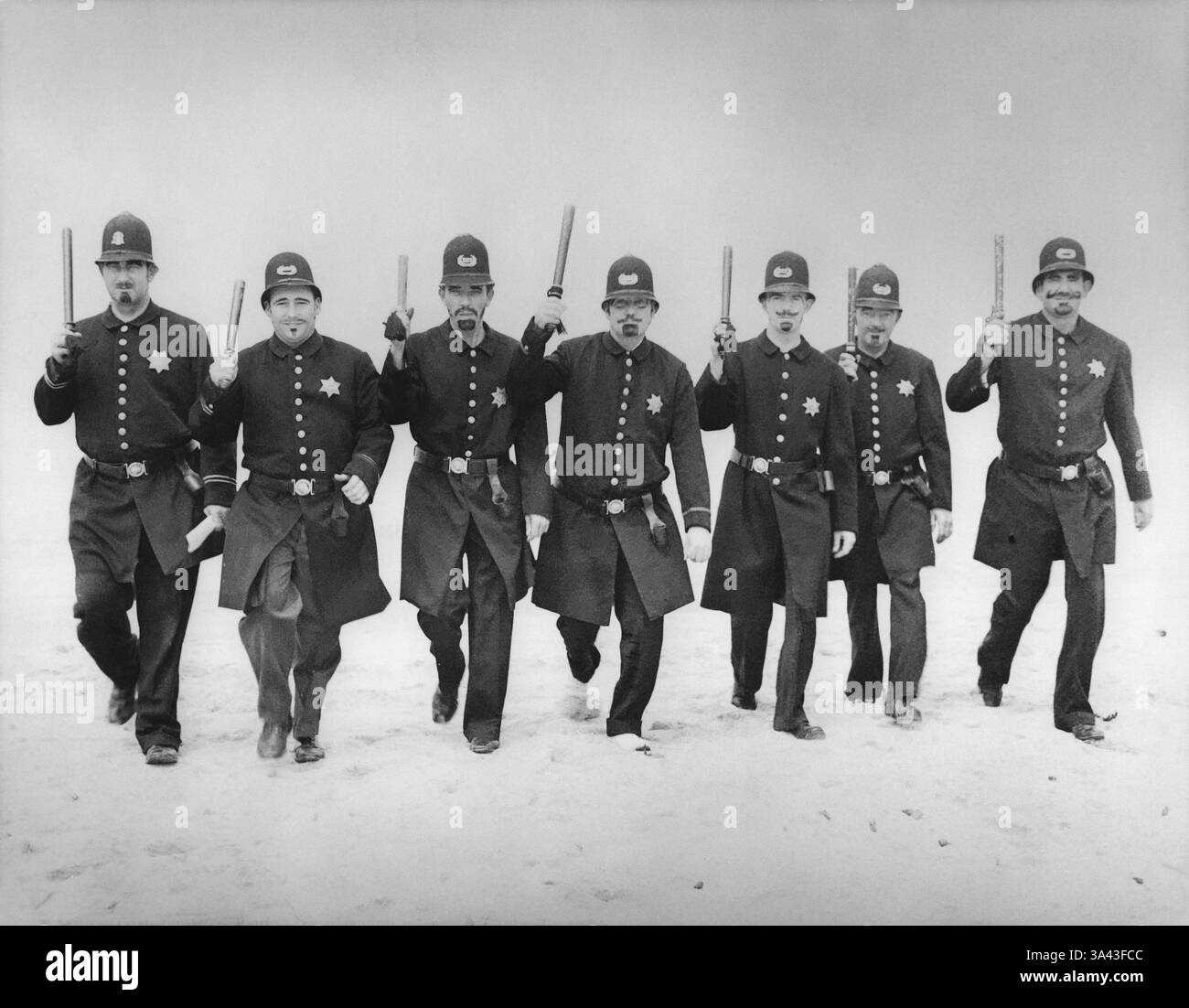 Seven Keystone cops in a row walking Stock Photo - Alamy