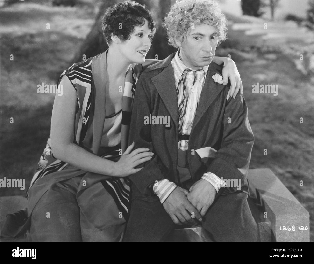 Harpo Marx sitting on a bench with a female costar in Animal Crackers ...