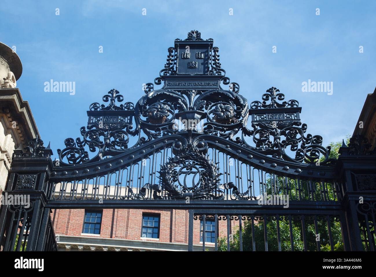 An Ornate iron gate and the historical brick buildings of Harvard ...