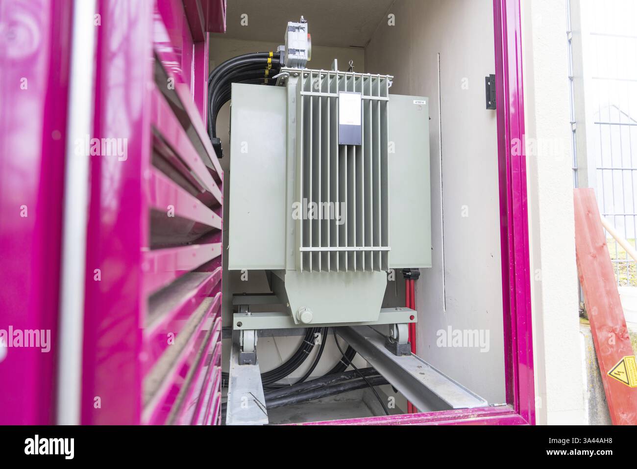 Transformer in a pink housing with grey paint in a technical environment, switch cabinet ...