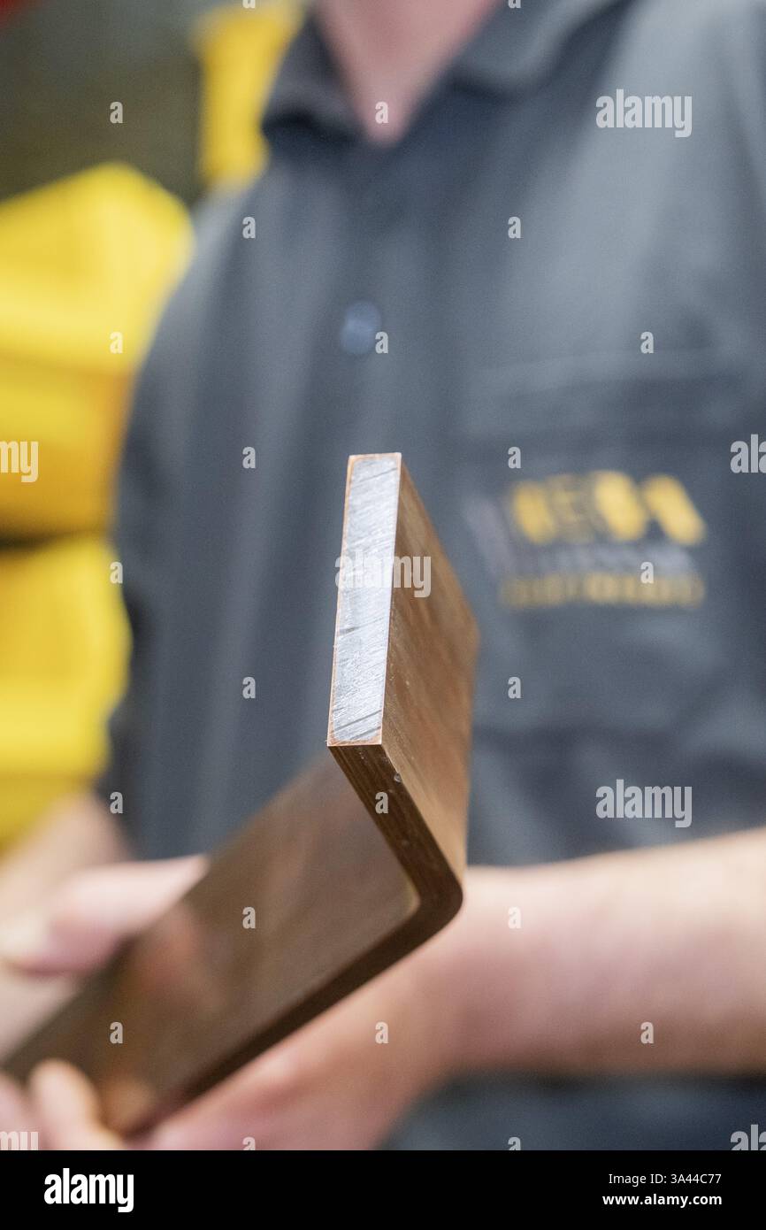 Close-up of a piece of metal being held by a person in workman's ...