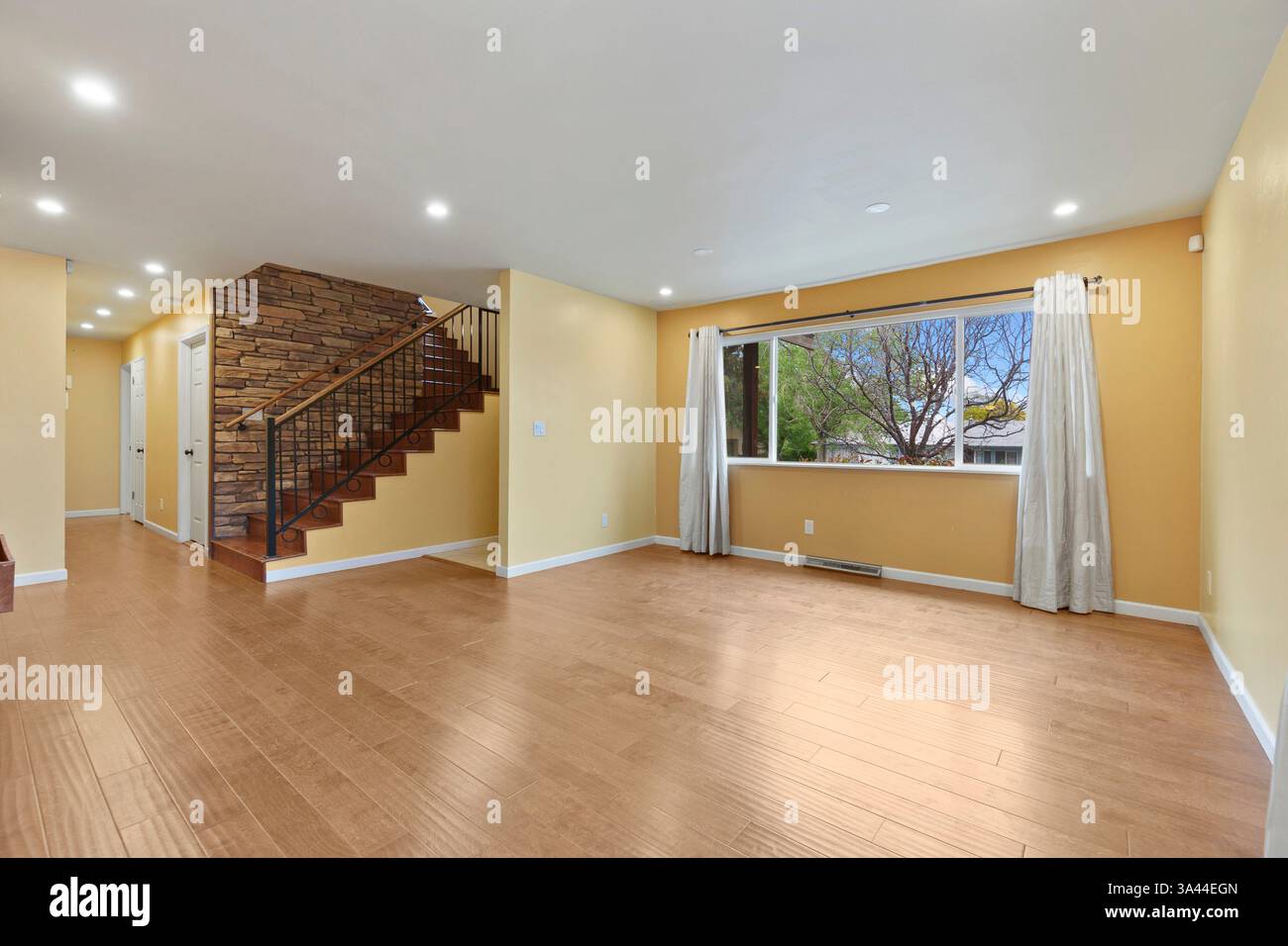 The living room is completely empty, showcasing its beautiful hardwood ...