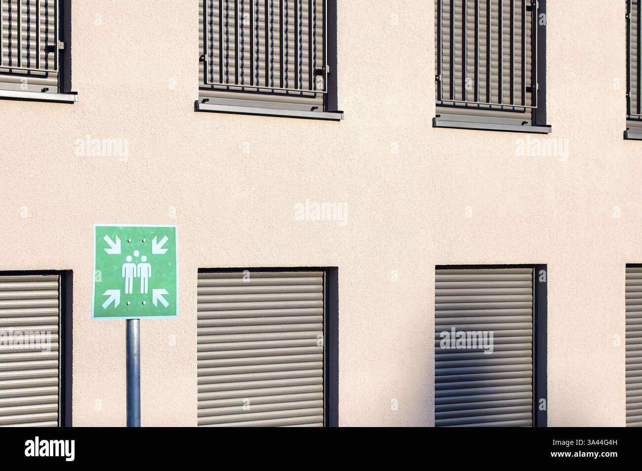 Green assembly point sign indicating gathering place in case of ...