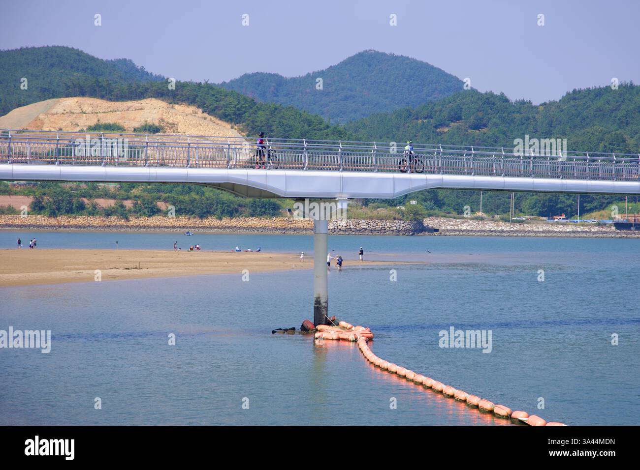 Gwangyang, South Korea - October 3rd, 2021: Two cyclists ride across ...